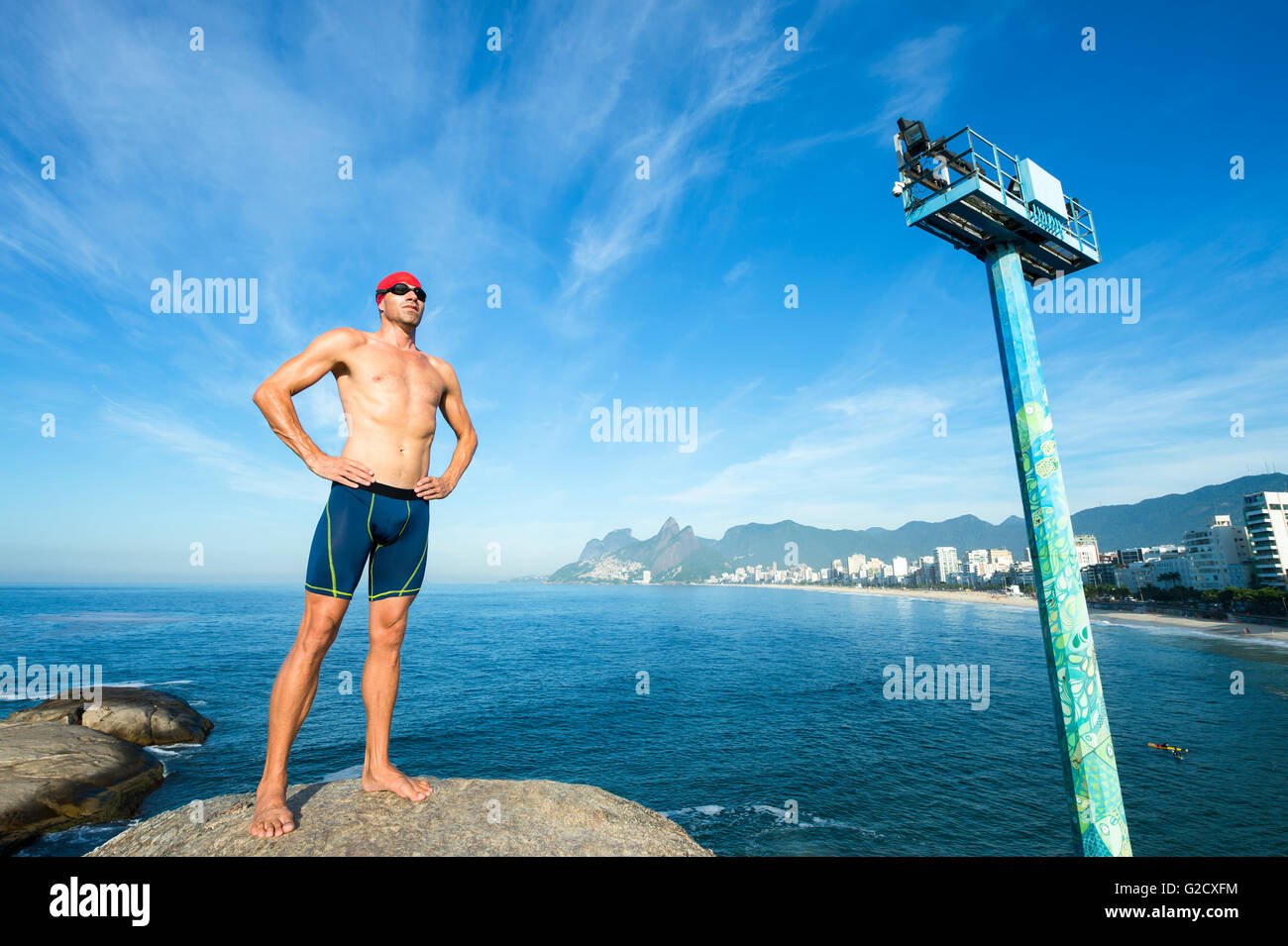 Athlete swimmer with red swimming cap standing with hands on hips in ...