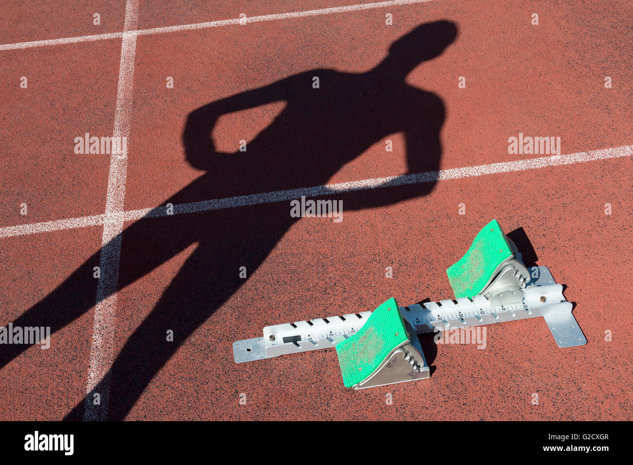 Track athlete casts shadow on starting blocks at the starting line of a ...