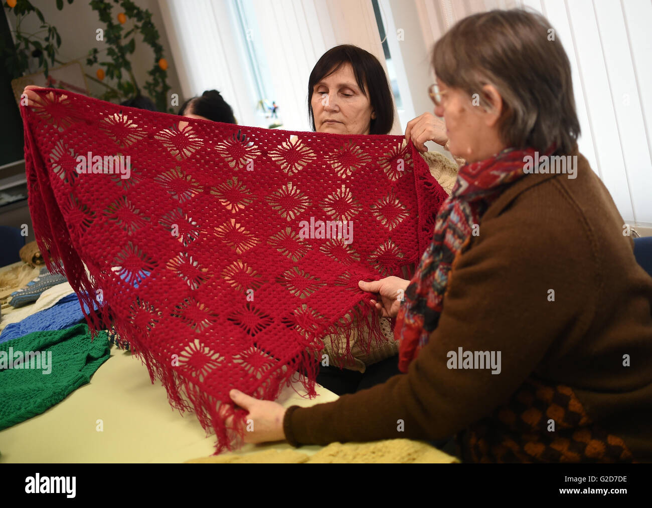A group of handcraft makers working on different lace and crochet ...