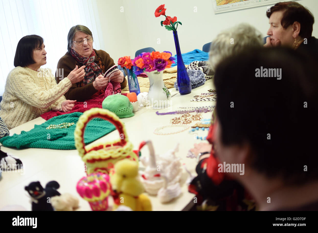 A group of handcraft makers working on different lace and crochet ...