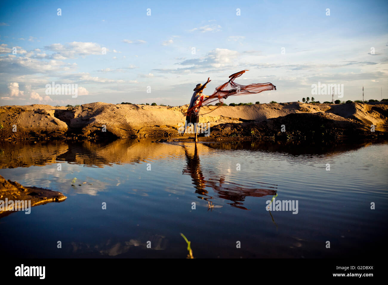 Young Man Tossing Fishing Net into Small Pond Stock Photo - Alamy