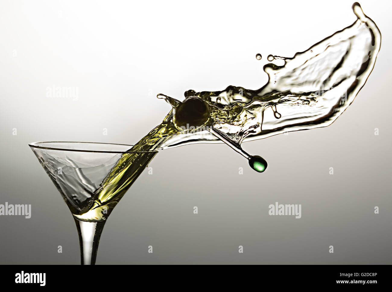 Yellow Martini Spilling out of Glass Stock Photo - Alamy