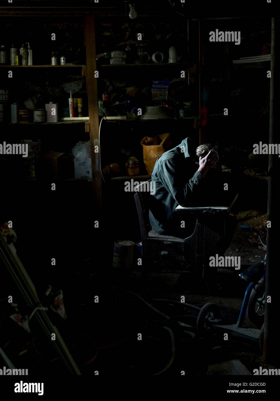 Man Sitting in Dark Basement Stock Photo - Alamy