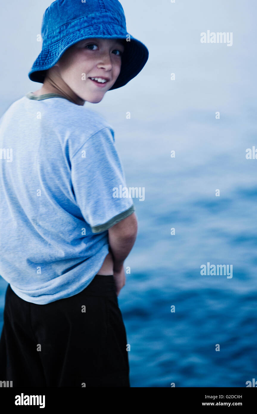 Surprised Boy Looking Over His Shoulder at Sea Stock Photo - Alamy