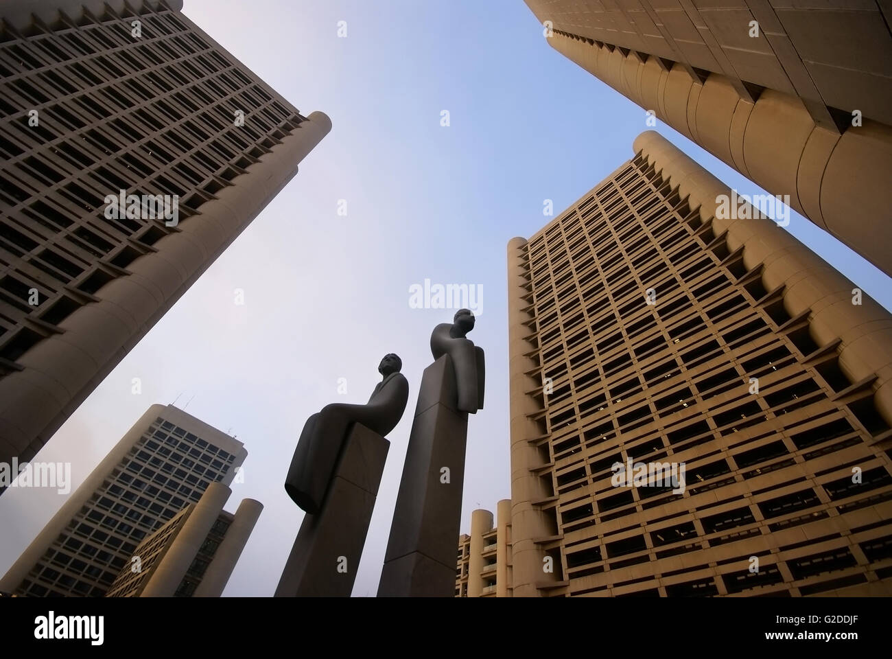 Two bronze statues among modern concrete high-rises at sunset Stock ...
