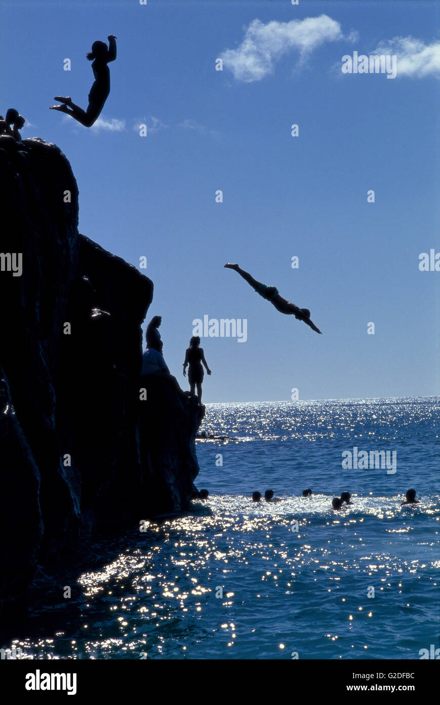 Group of People Jumping off Cliff into Water Stock Photo - Alamy