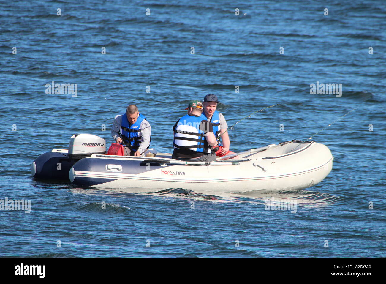 Three fishermen do a spot of sea angling on the Firth of Clyde, from a ...