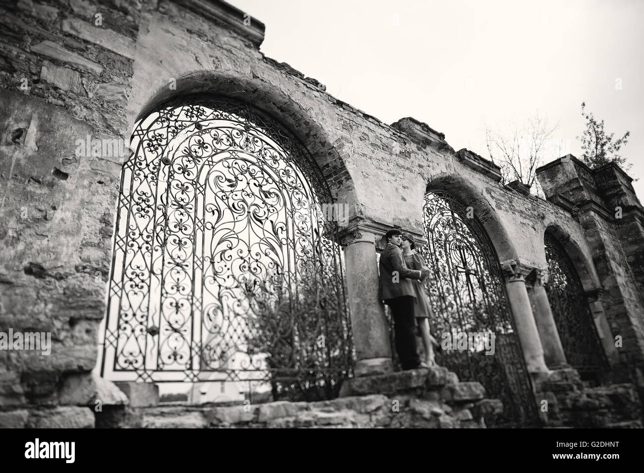 Couple hugging in love background old gates of castle. Stylish man at ...