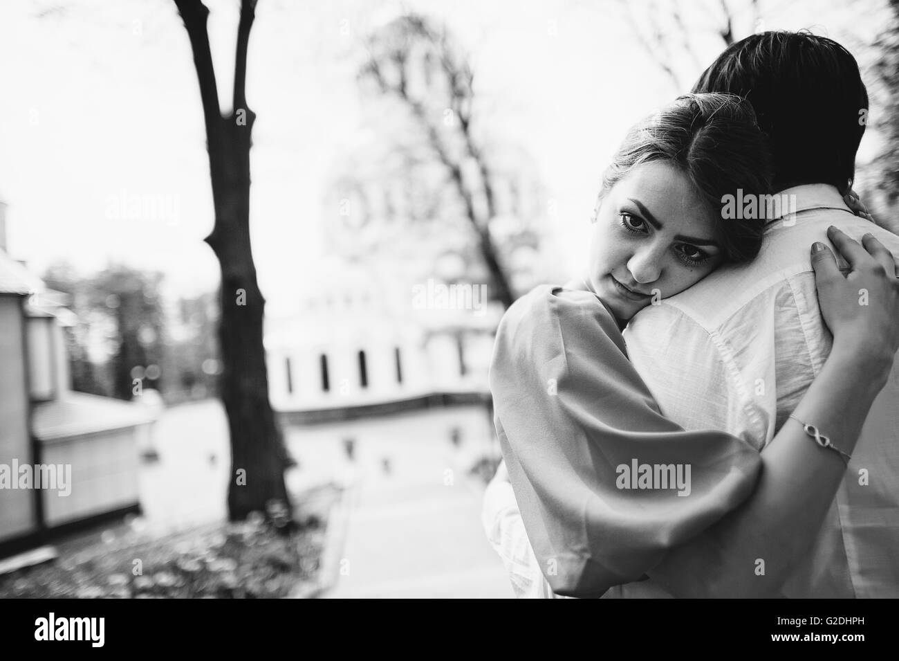 Couple hugging in love background church. Stylish man and girl in red ...