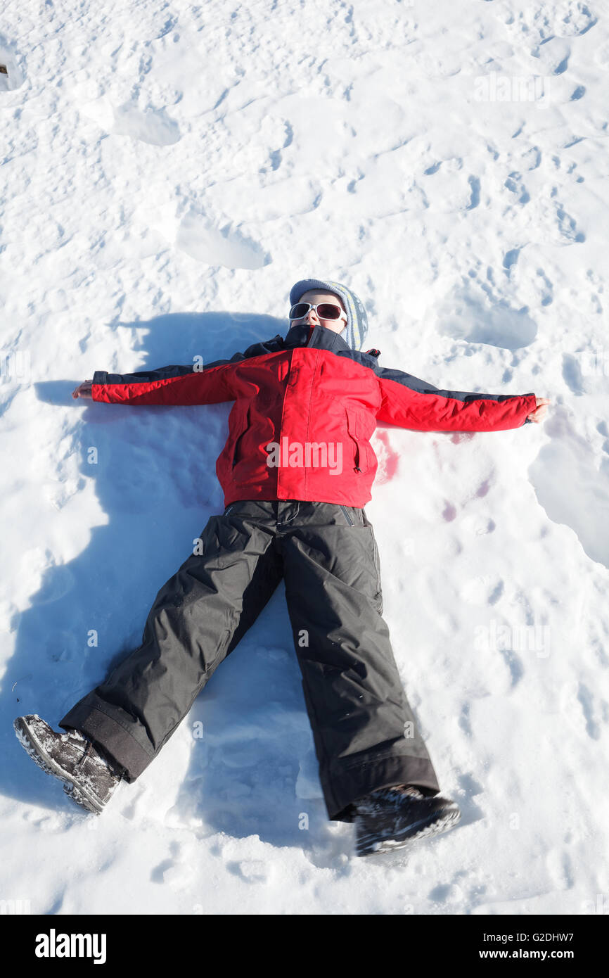 Boy making an angel in the snow Stock Photo - Alamy