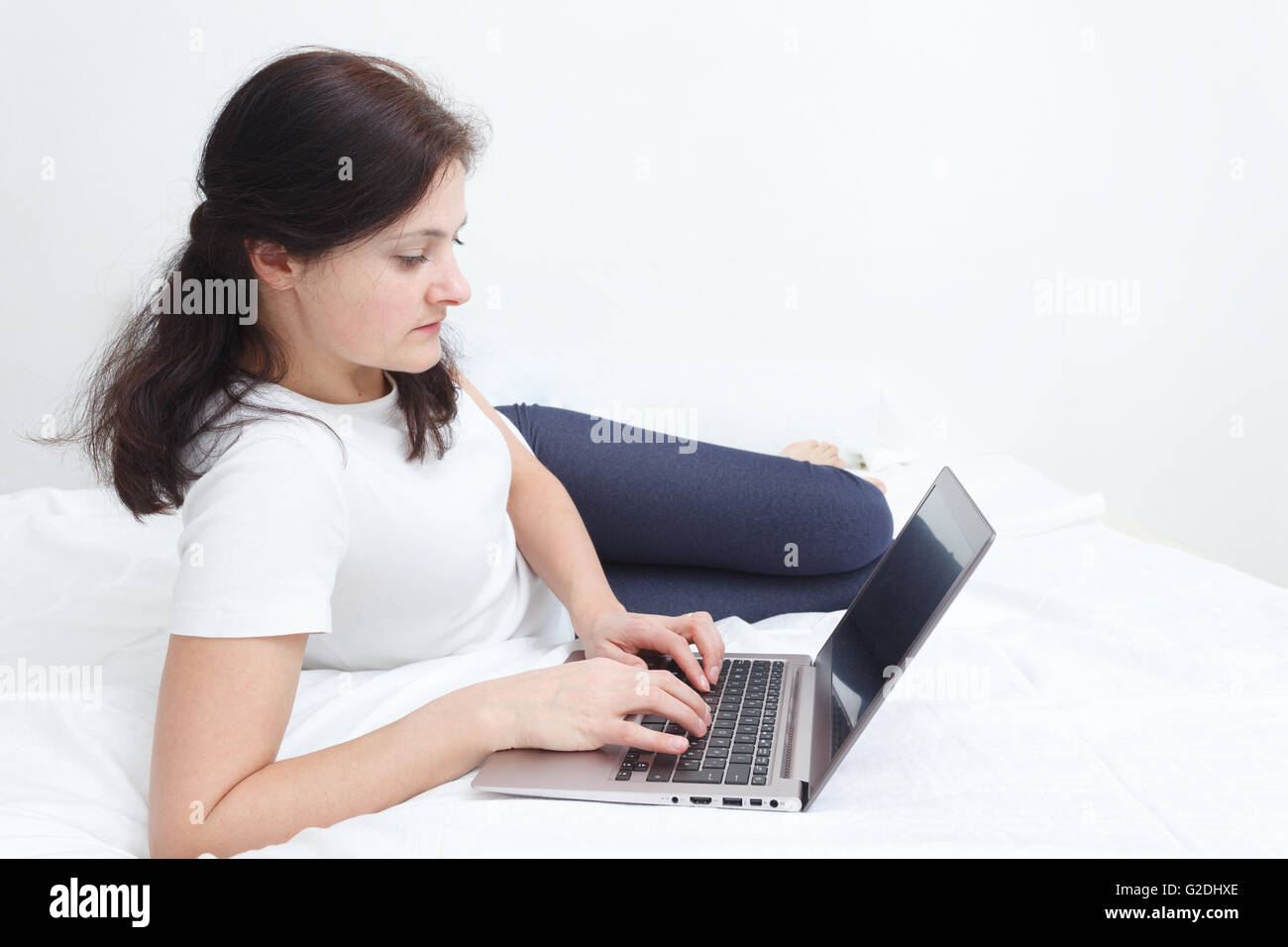 woman laying on bed with a laptop working from home Stock Photo - Alamy