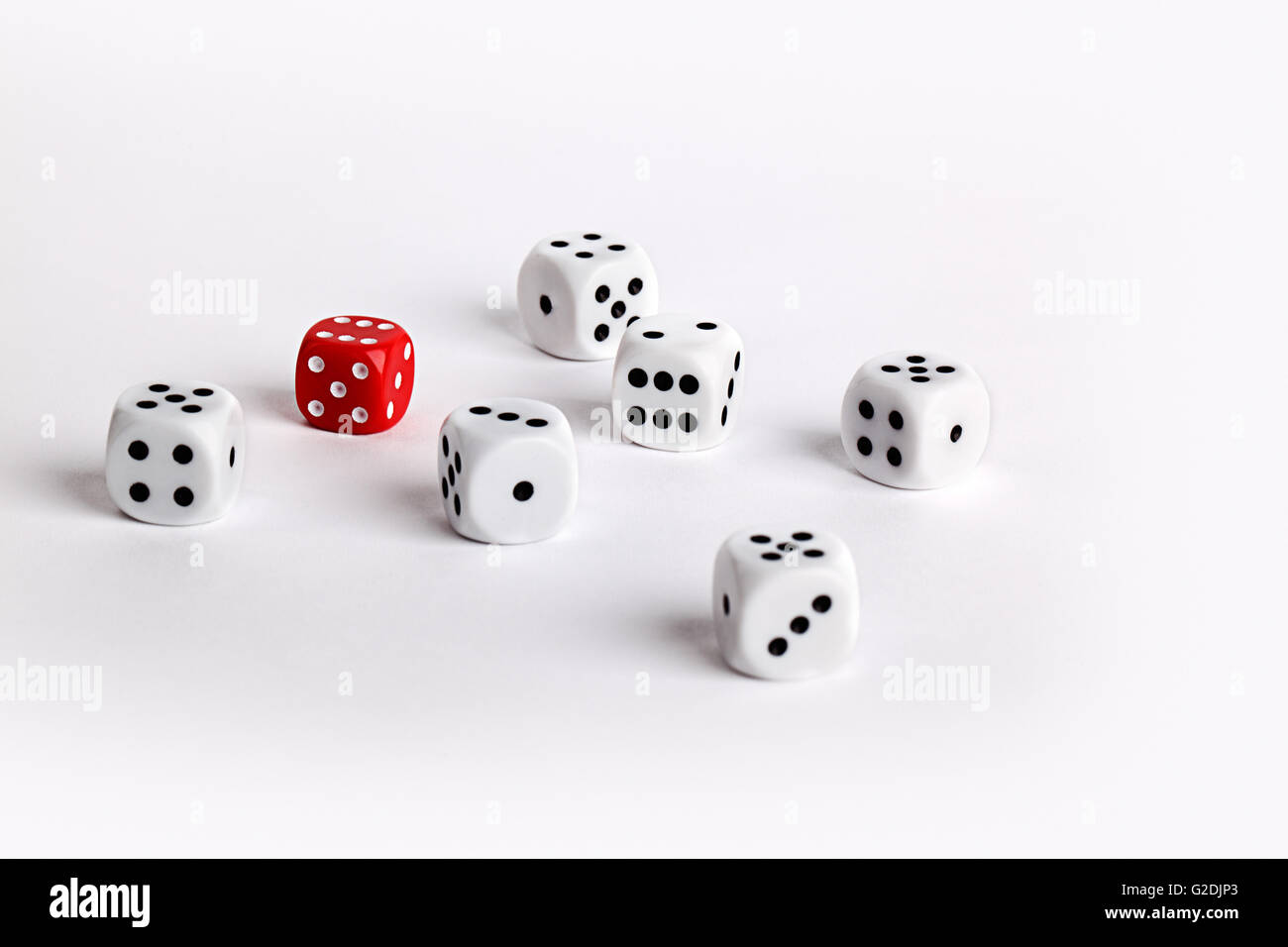 Randomly scattered white dice with one red dice conceptual of ...