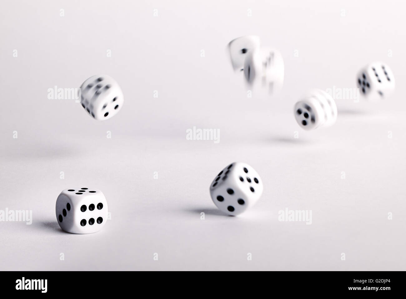 Multiple thrown dice bouncing across a white surface with movement and ...