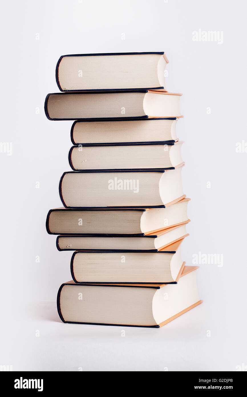 Stack of hardcover books with spines facing away from the camera on a ...