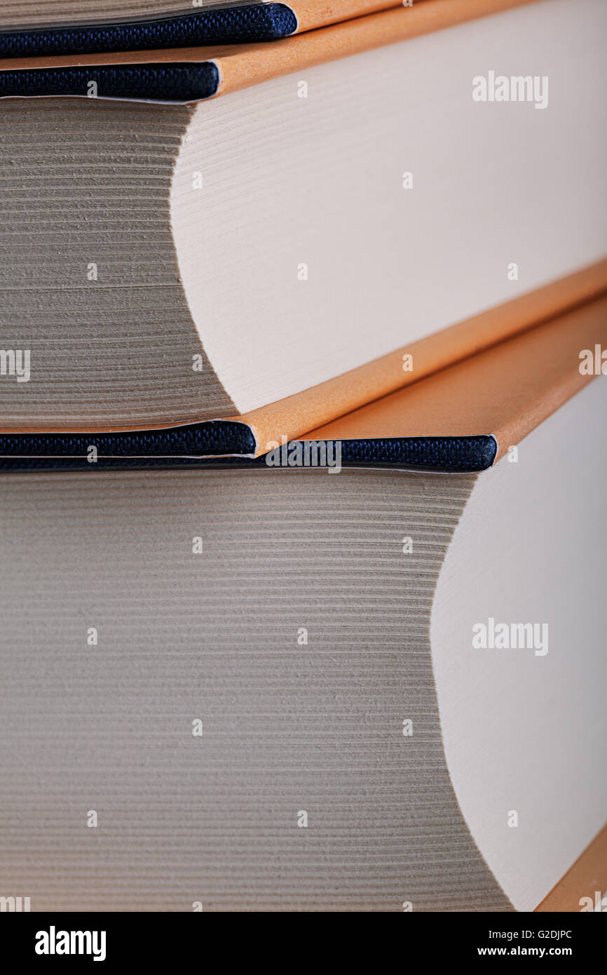 Stack of hardcover books with spines facing away from the camera on a ...