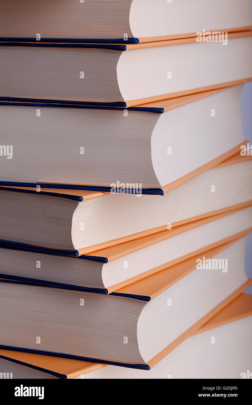 Stack of hardcover books with spines facing away from the camera on a ...