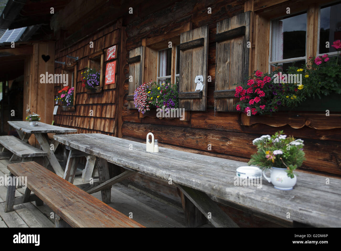 Old wooden Alpine Cabin with outdoor tables and benches in Austria ...