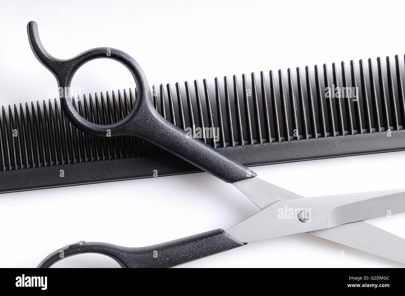 Barber scissors over comb closeup on a white table, isolated on white ...