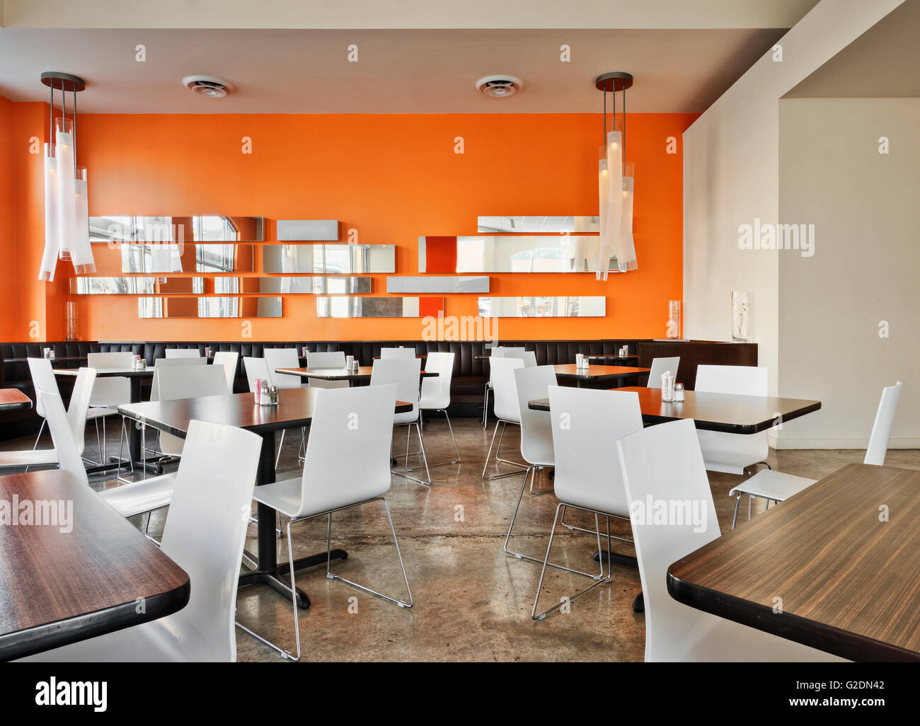 Modern Café with Orange Walls and White Chairs Stock Photo - Alamy