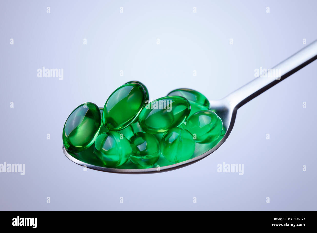 Green nutritional supplement pills in a spoon Stock Photo - Alamy