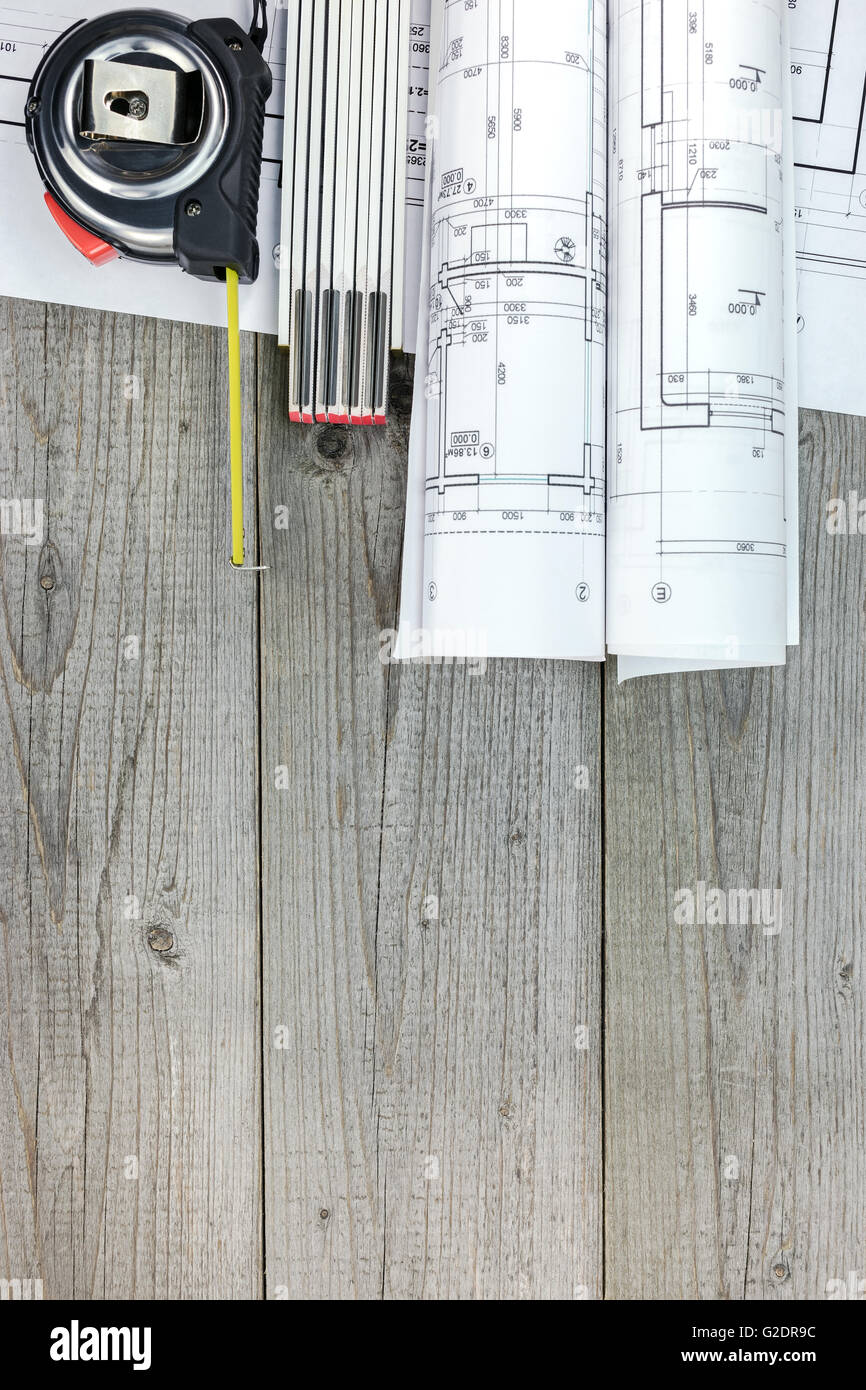 rolls of architectural blueprints with tools measurement on wooden desk ...