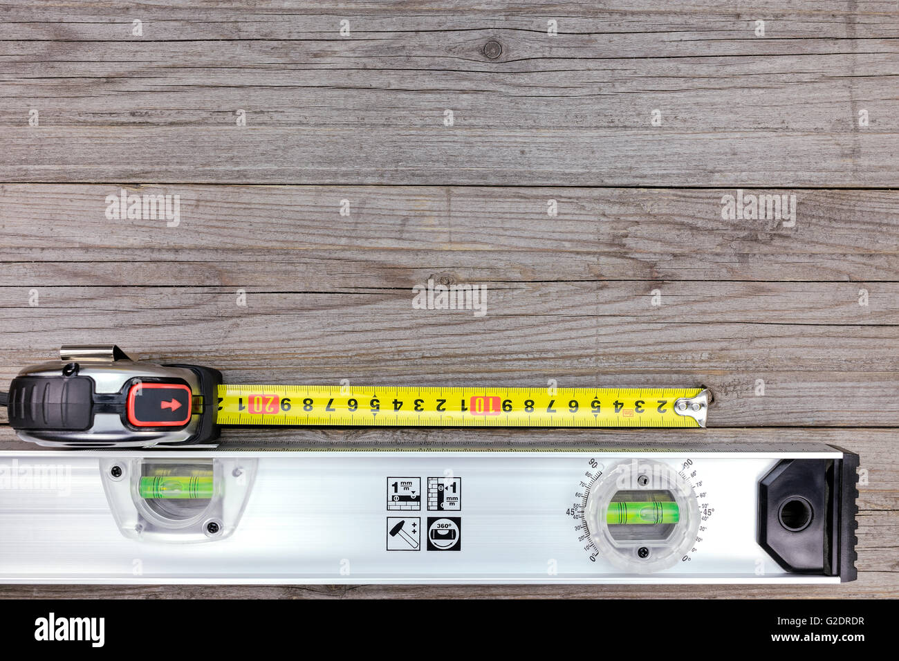 spirit level with tape measure on gray wooden background Stock Photo ...