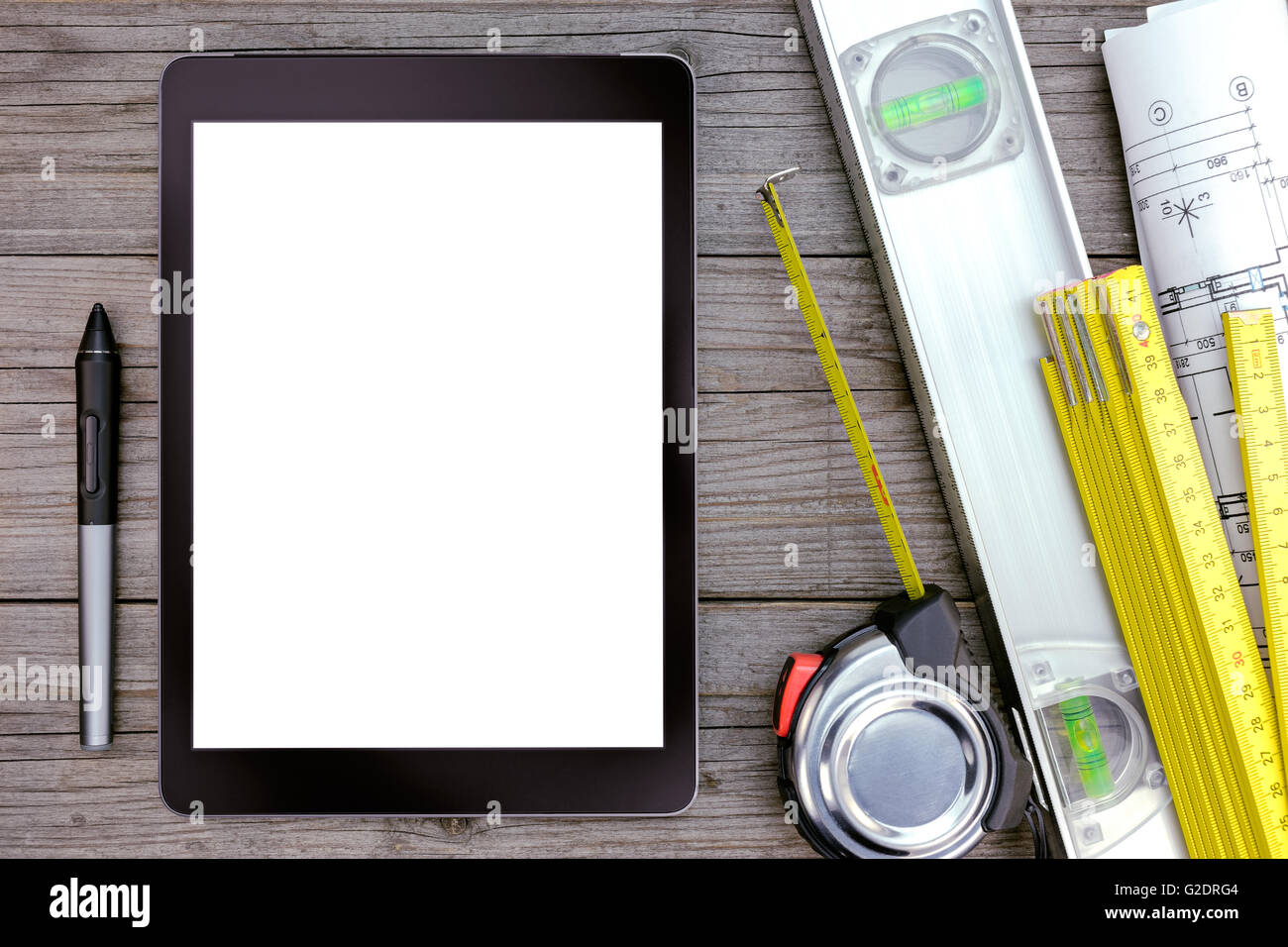 tablet computer with architectural blueprints and construction tools on ...