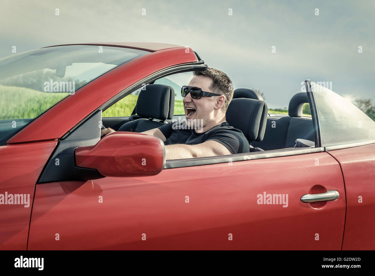 Angry man driving a car. Toned image Stock Photo - Alamy
