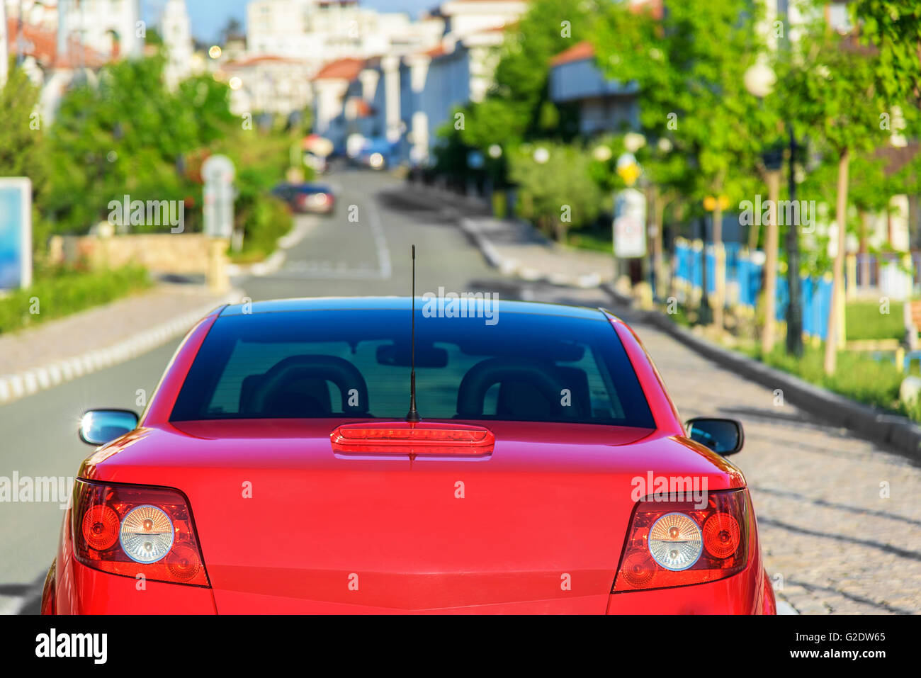 Red car on a city street a beautiful sunset Stock Photo - Alamy