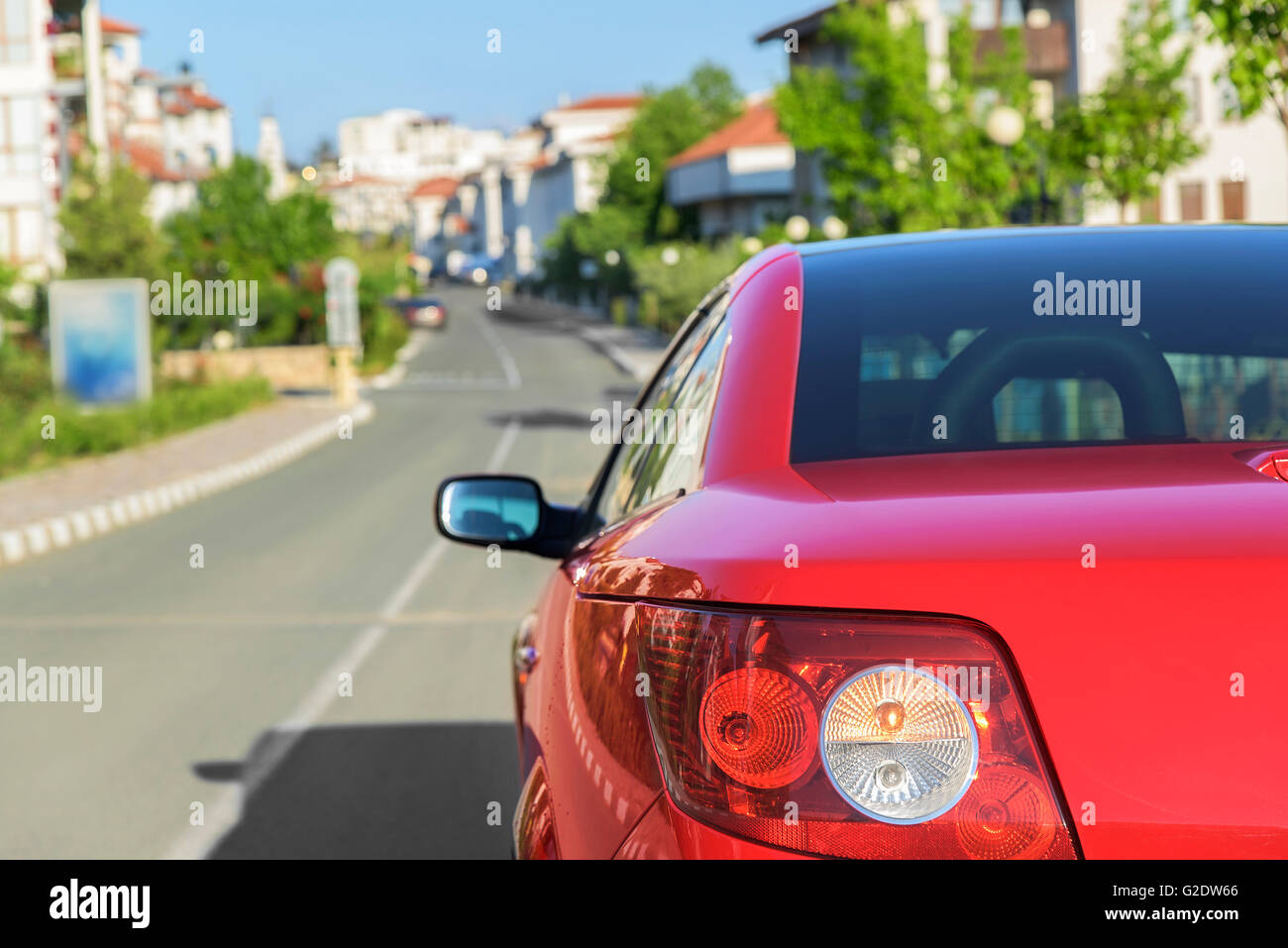 Red car on a city street a beautiful sunset Stock Photo - Alamy