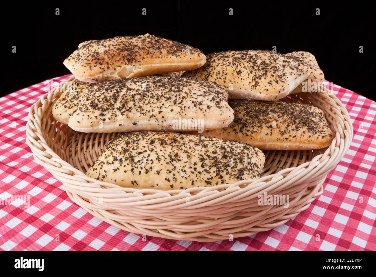 oregano buns in a basket on red table Stock Photo - Alamy