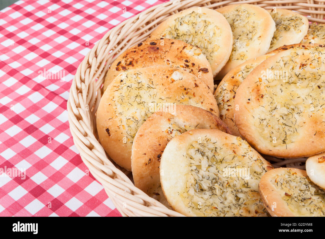 Round garlic flatbred in basket on red table Stock Photo - Alamy
