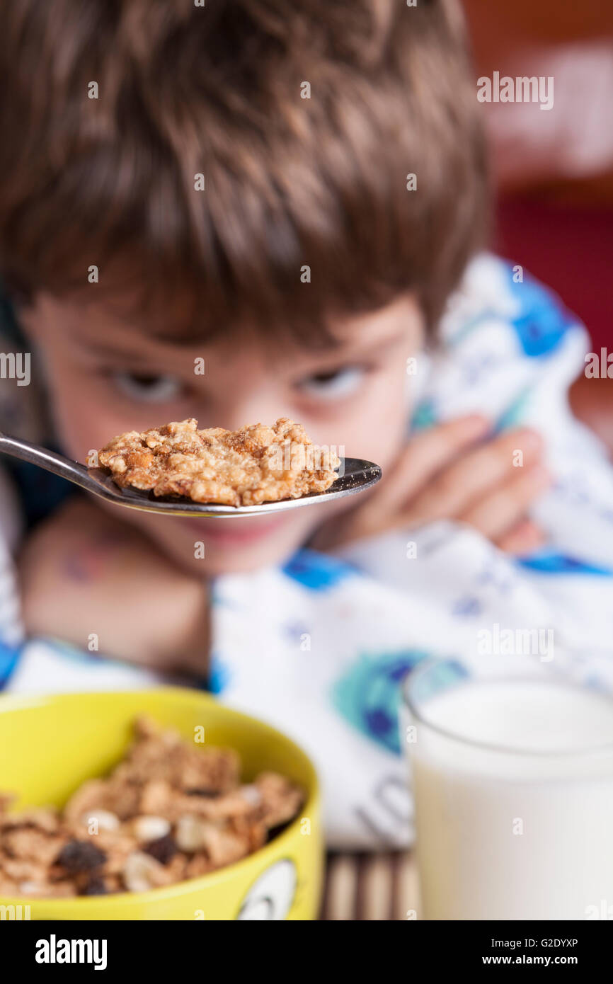 Macro shoot of cereals on teaspoon with little boy in the background ...