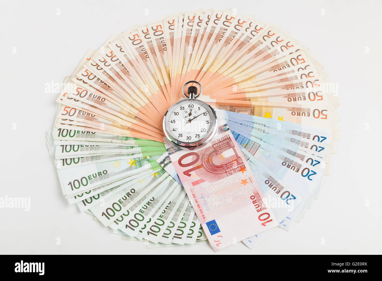 Circle made of euro banknotes with silver analog stopwatch in the ...