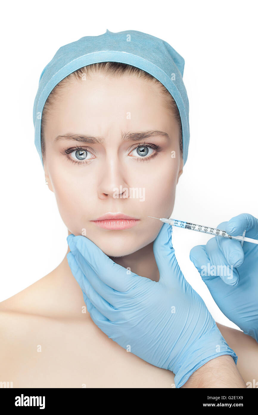 Attractive surprised and scared woman at plastic surgery with syringe ...
