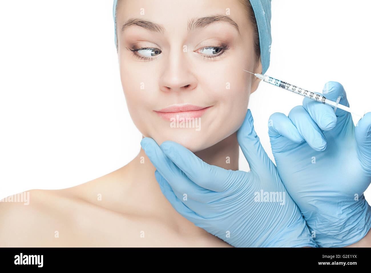 Attractive surprised and scared woman at plastic surgery with syringe ...