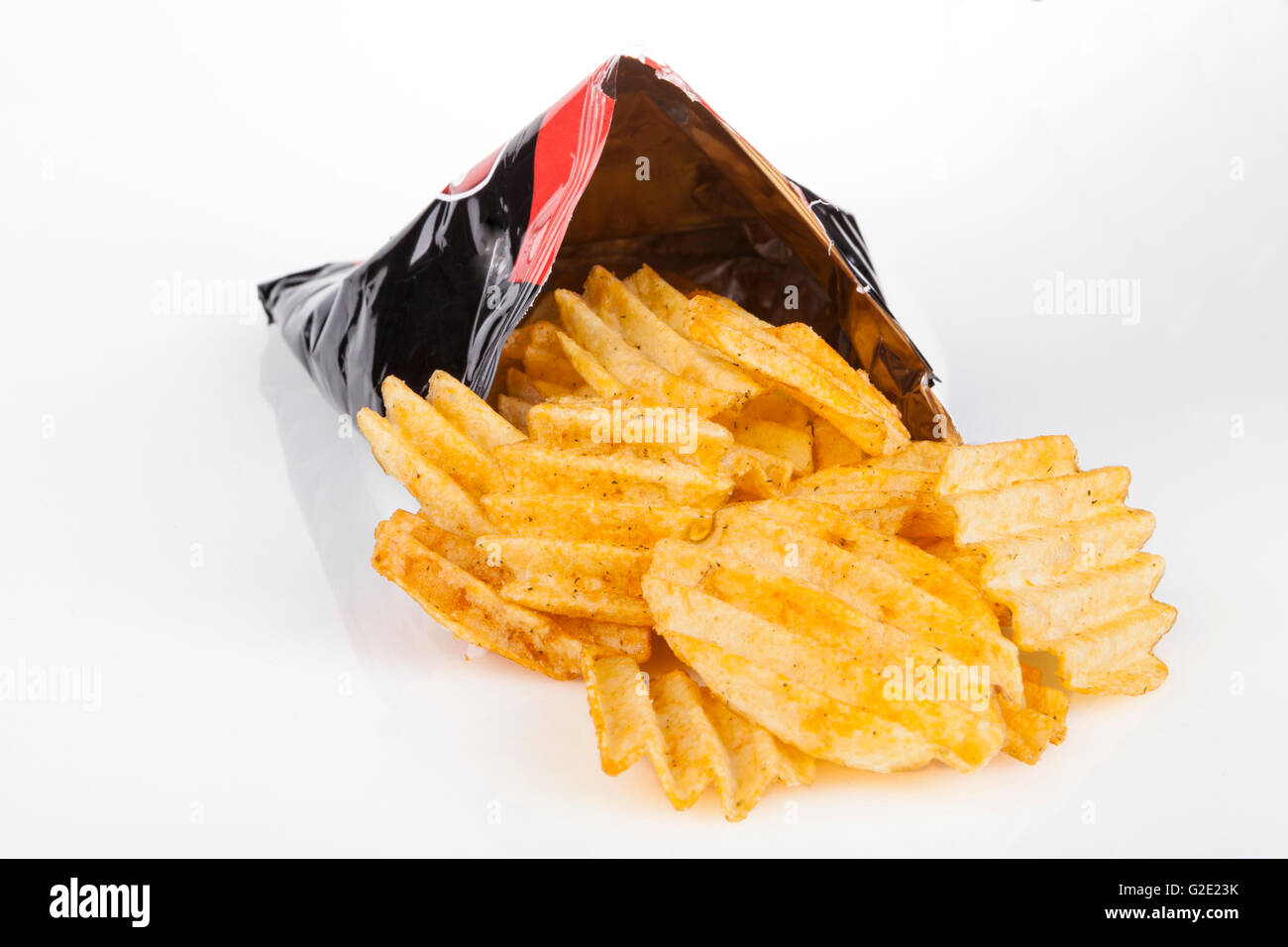 Golden poatato chips pouring out os a bag on white background Stock ...