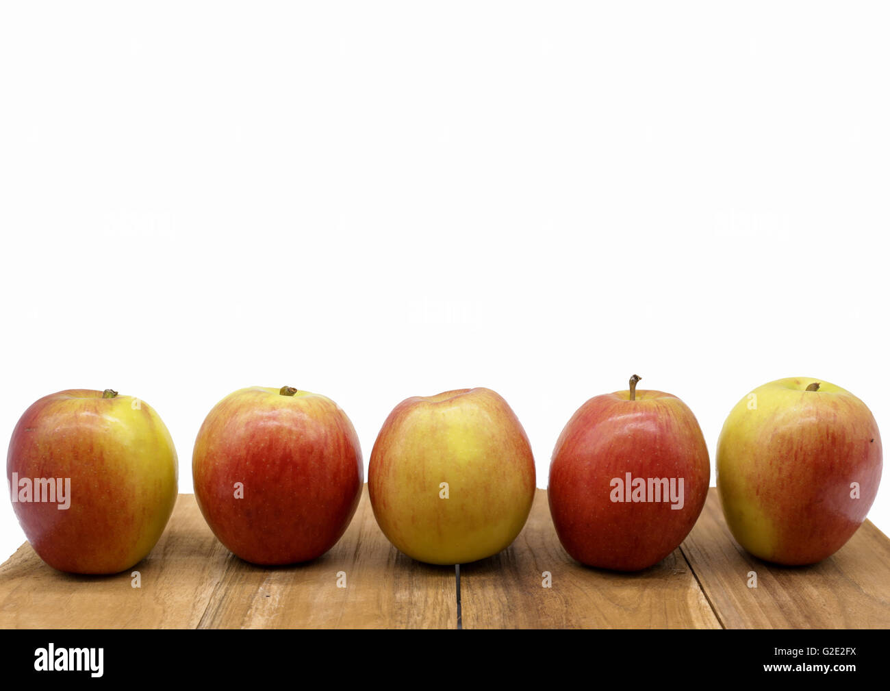 Five apple line up on wood block on white background Stock Photo - Alamy