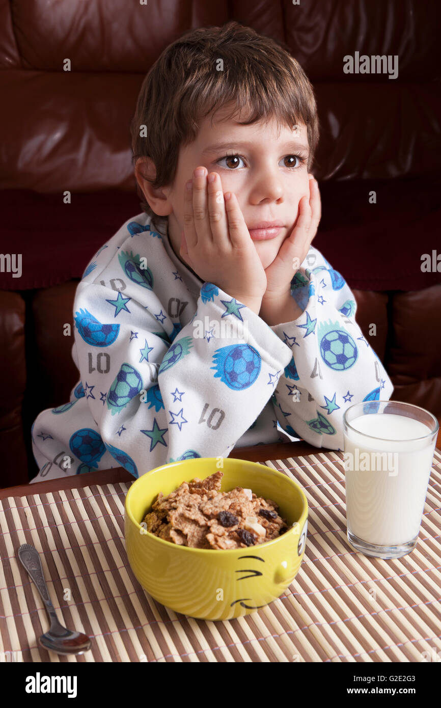 Boy not eating breakfast cereals and milk on the table Stock Photo - Alamy