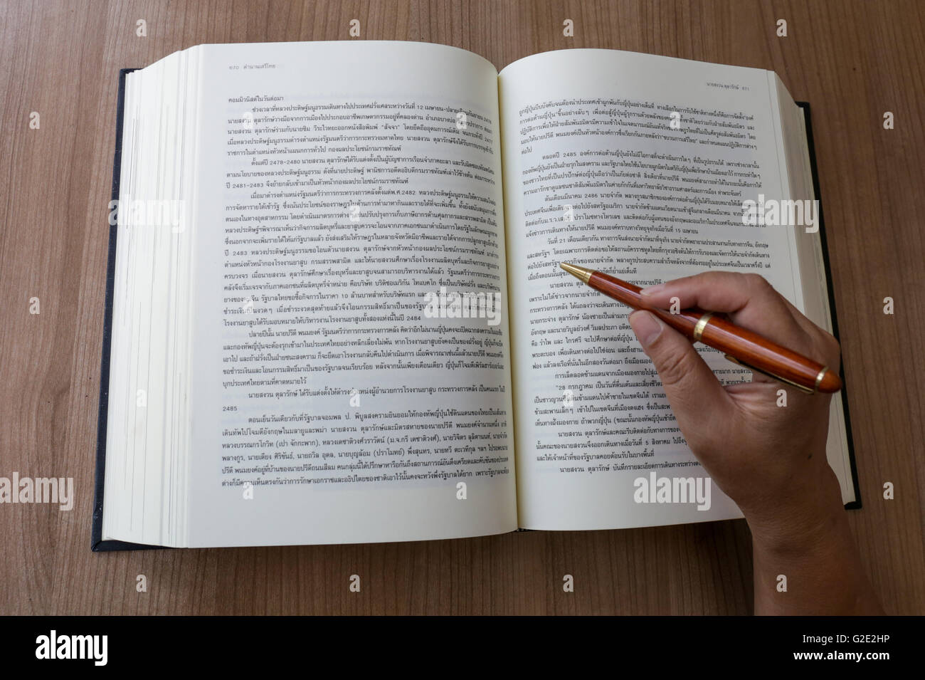 Reading documentary on wood table Stock Photo - Alamy