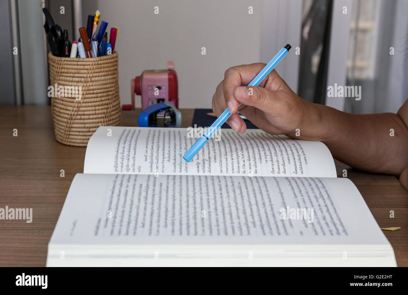 Reading book on working table Stock Photo - Alamy