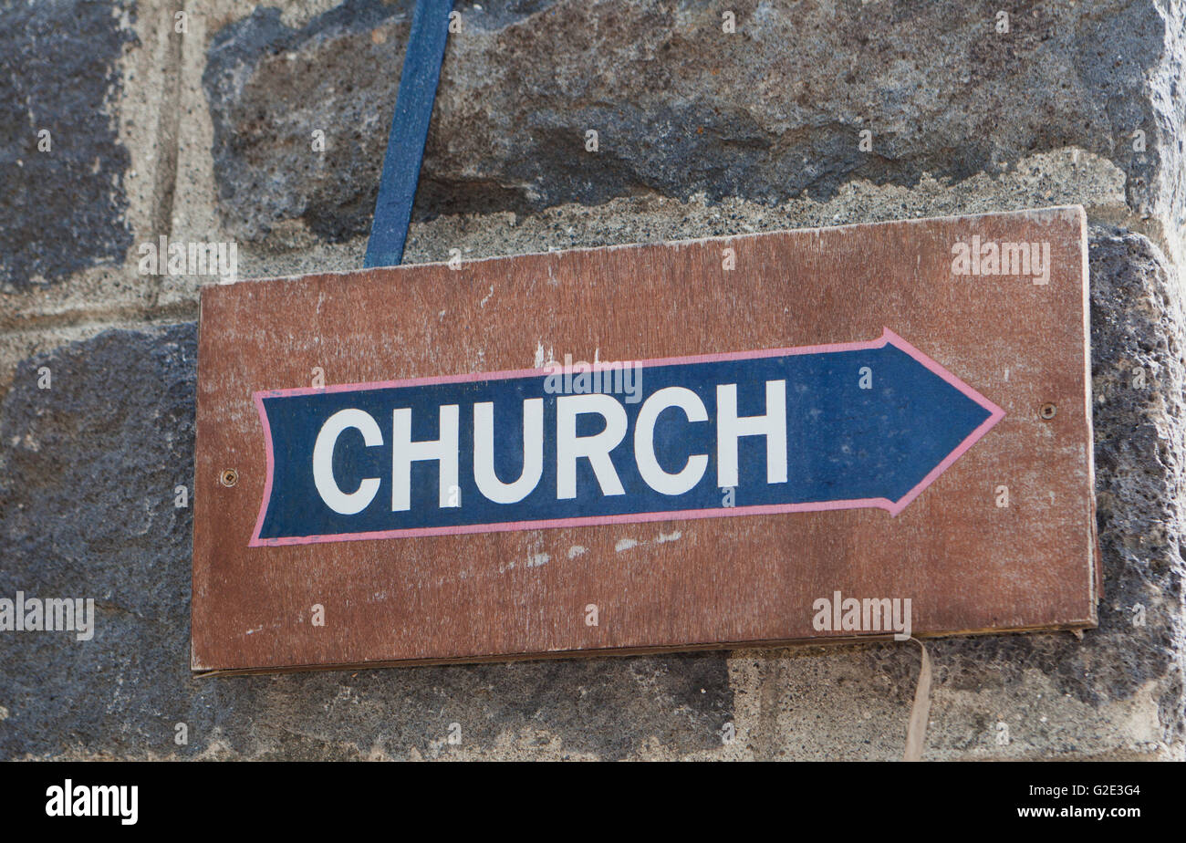 old brown wood church sign with blue arrow on dark stone wall Stock ...