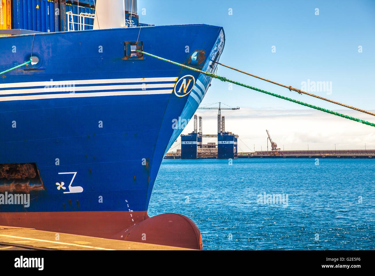 Moored blue-coloured ship loaded with containers Stock Photo - Alamy