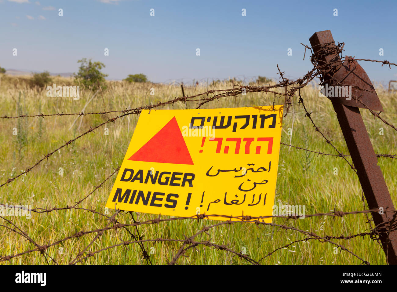 Minefield sign on a barbed wire fence in hebrew arabic and english ...