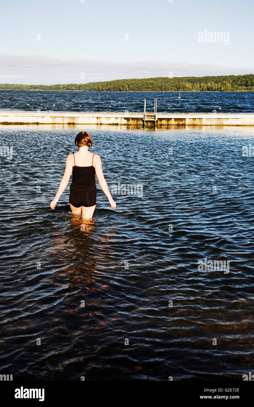 Woman Walking into Water Stock Photo - Alamy