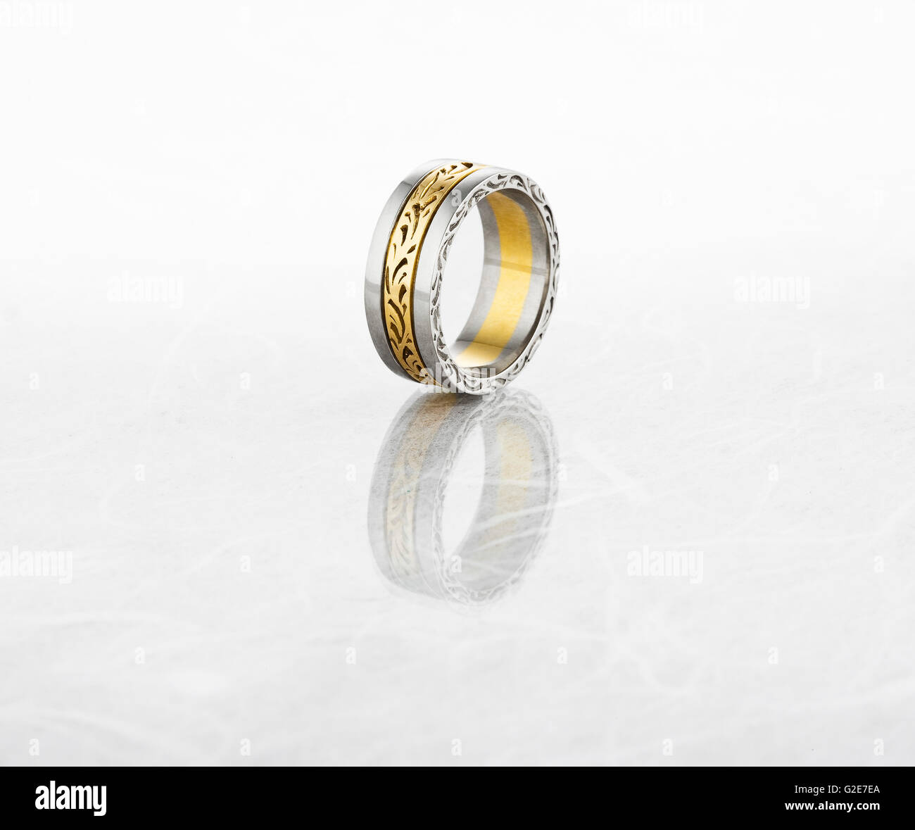 Gold and Silver Ring on Reflective Surface Stock Photo - Alamy