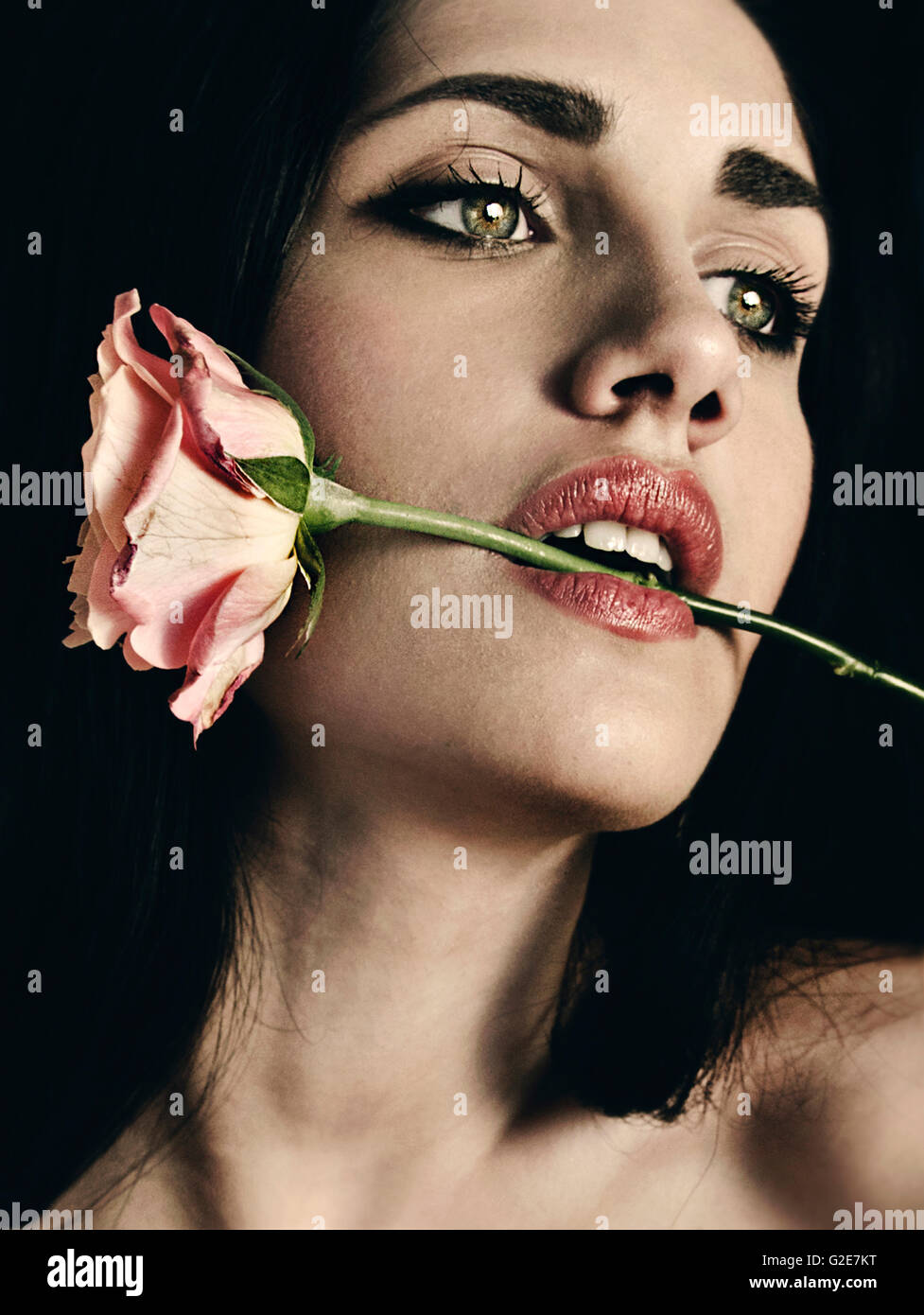 Young Adult Woman Biting Rose Stem Stock Photo - Alamy