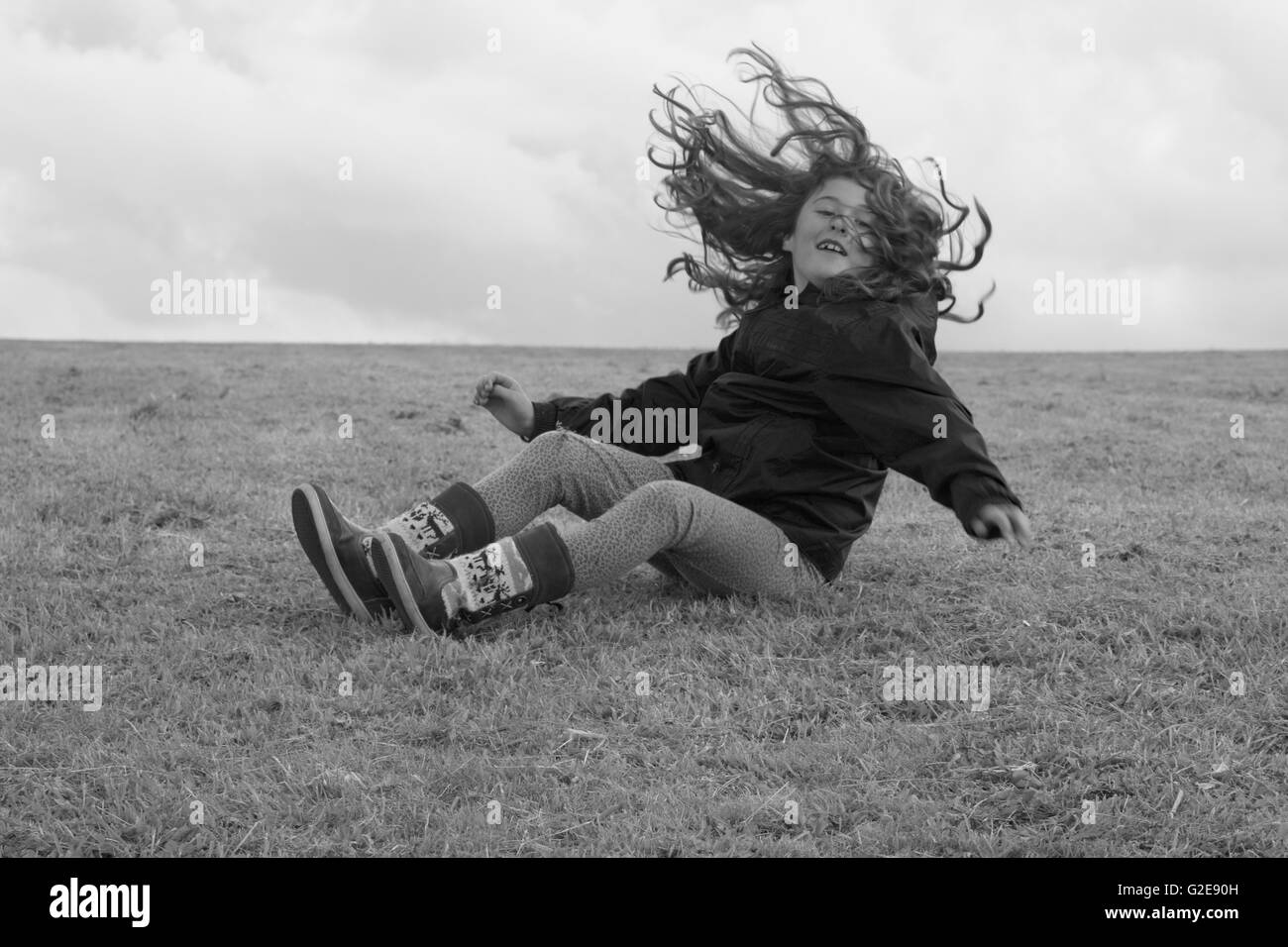 Young Girl Having Fun and Falling on Ground Stock Photo - Alamy