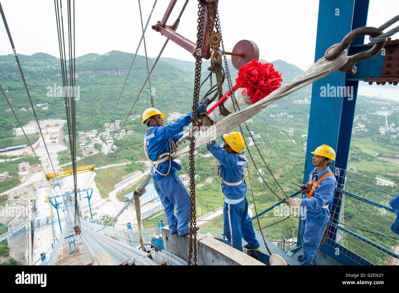 Chongqing, China. 30th May, 2016. Workers install the last main cable ...