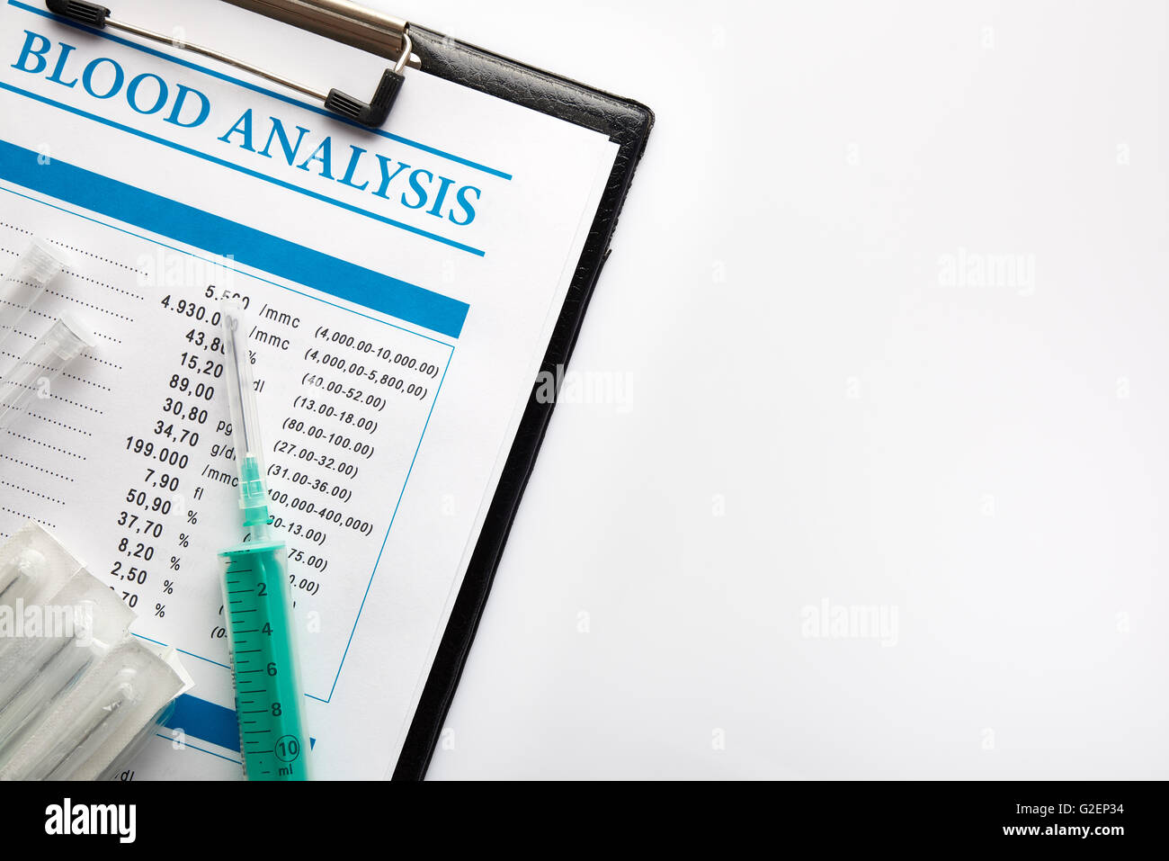 Blood test report in a black folder with vials and syringe over white ...
